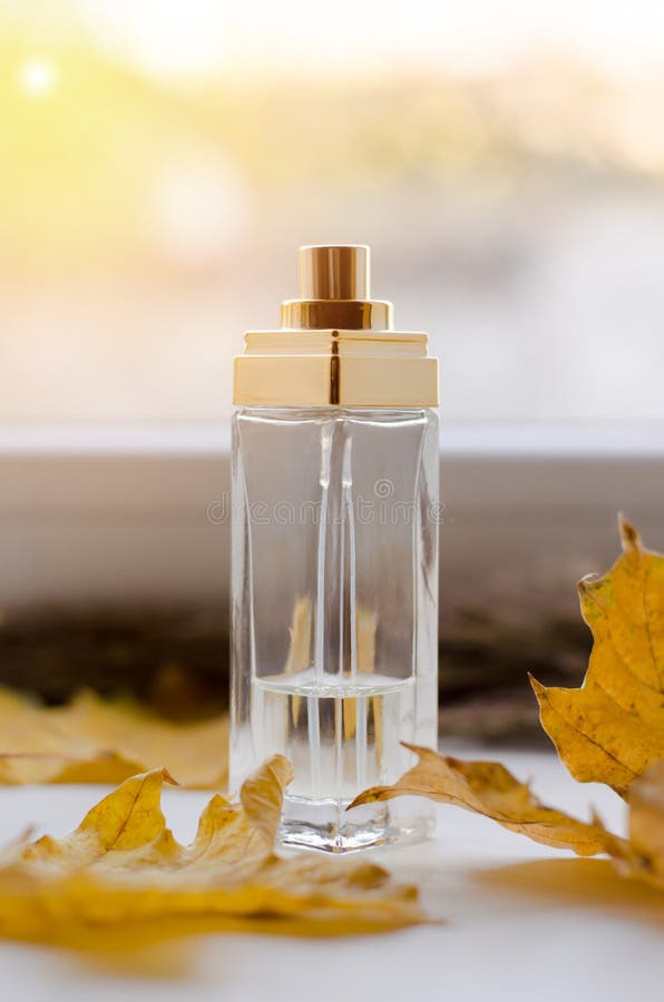 Perfume Bottle in the Sun with Yellow Autumn Leaves Stock Image - Image ...