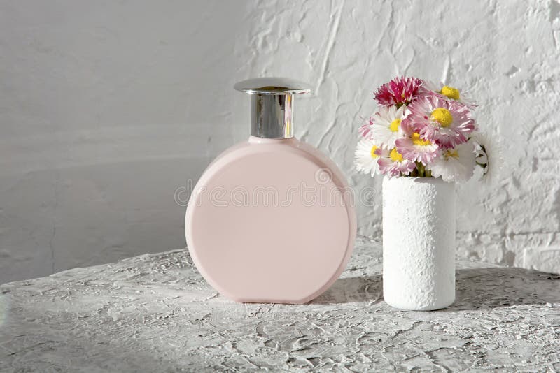 Perfume in a Pink Powder Bottle and Daisies on a Light Texture ...