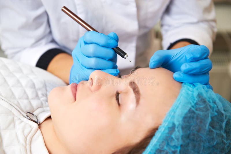 Permanent Make-up Wizard Makes Eyebrow Correction Procedure. Stock ...