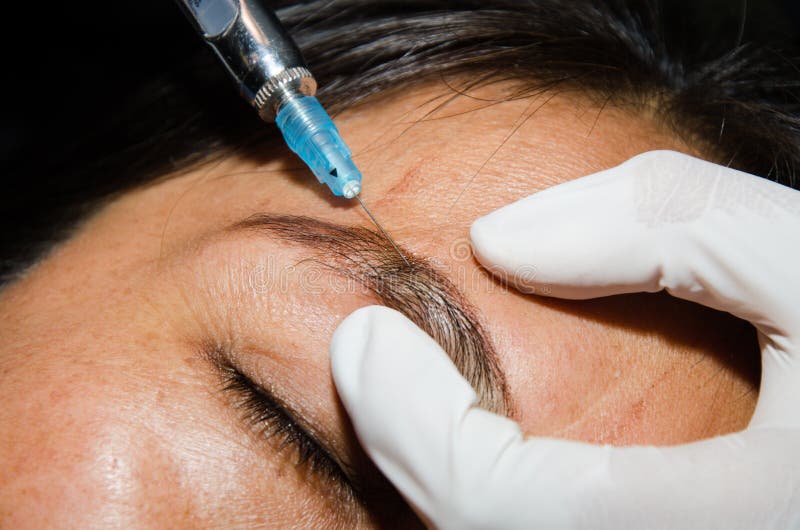 Permanent Makeup Tattooing of Eyebrows. Cosmetologist Applying ...