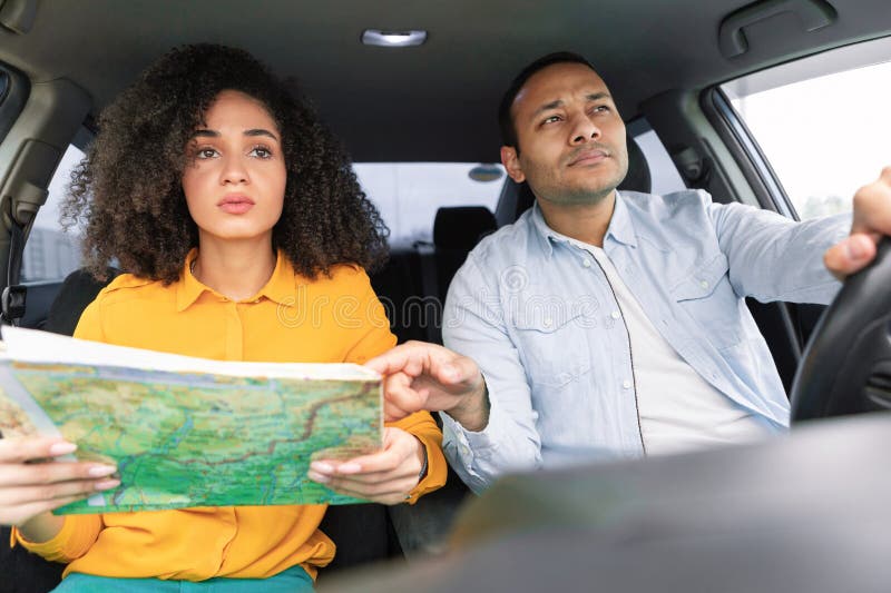 Perplexed Arab Couple Riding Car Holding and Pointing at Map Stock ...