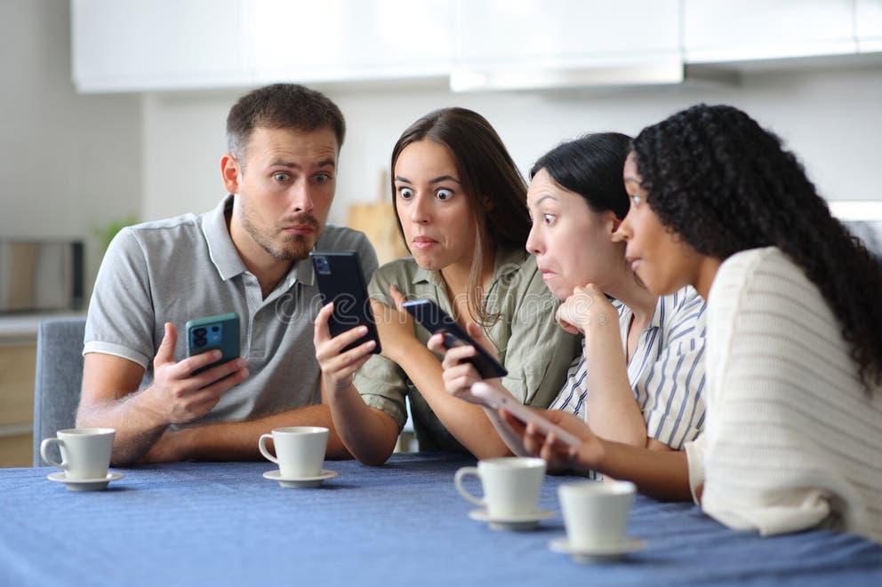 Perplexed Group of Friends Checking Phones in the Kitchen Stock Photo ...