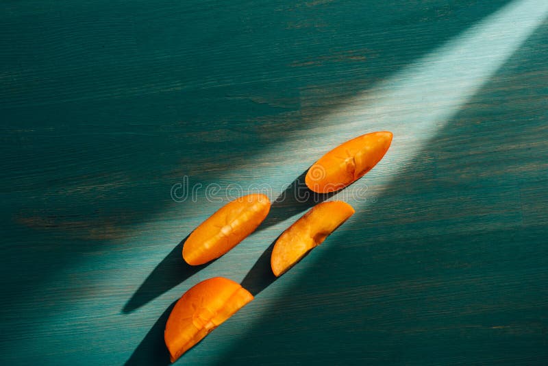 Persimmon Persimmon Pieces on Table with Light and Shadow Stock Photo ...