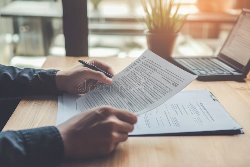 A Person Analyzes Financial Data and Charts, Taking Notes with a Pen ...