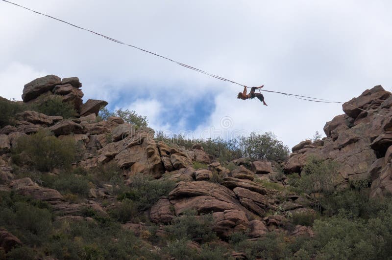 A Person is Balancing on a Tightrope Stretched between Rocky Cliffs ...