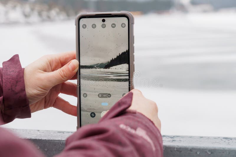 A Person Capturing a Scenic Winter Landscape with a Smartphone in an ...
