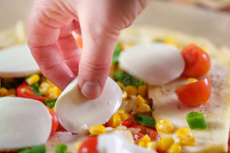 Person Carefully Adding Cheese Slices To Pizza, Process of Making Pizza ...