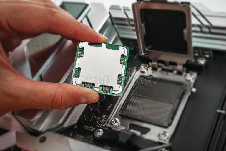 A Person is Carefully Holding a Computer Processor Above a Motherboard ...
