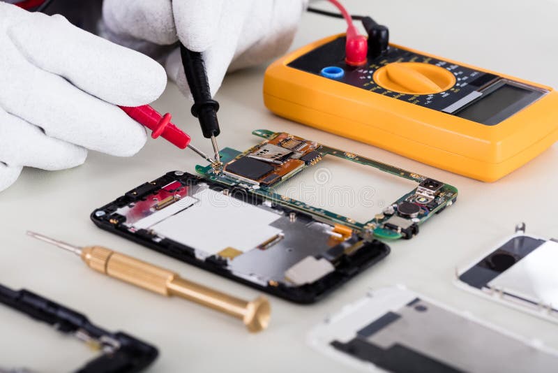 Person Checking Mobile Phone with Digital Multimeter Stock Photo ...