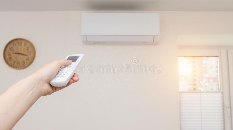 A Person Controls the Air Conditioner at Home with a Remote Control ...