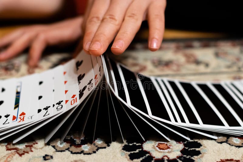 A Person Doing a Ribbon Spread with His Playing Cards Stock Image ...