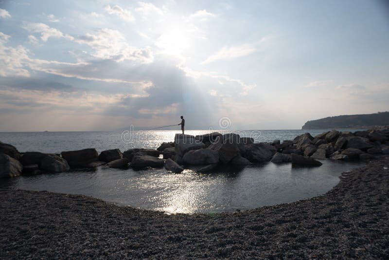 Person Fishing Standing on the Rocks at the Beach Stock Photo - Image ...