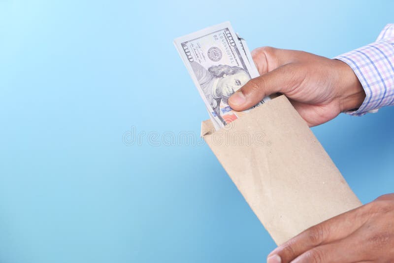 Person Hand Putting Cash in a Envelope on Blue Background Stock Image ...