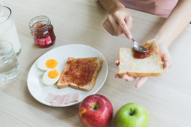Person Having Breakfast on the Table Eat Apple, Egg, Jam and Milk the ...