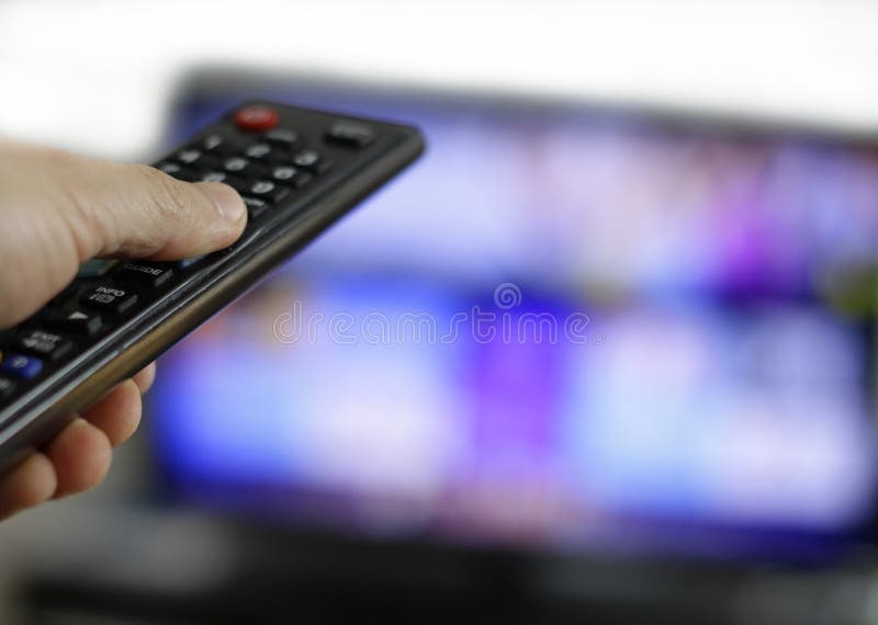Person Holding a Black Remote Control in Front of the TV Stock Photo ...