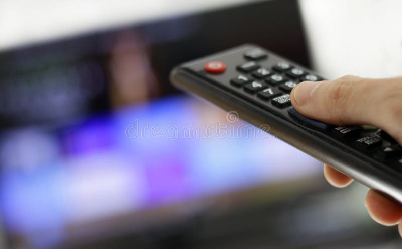 Person Holding a Black Remote Control in Front of the TV Stock Photo ...