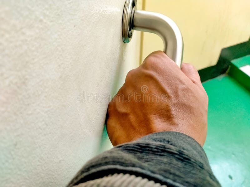 The Person is Holding the Door Handle for Walk in To the Room Stock ...