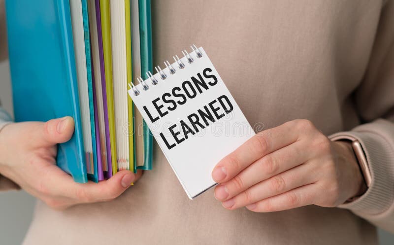 A Person is Holding a Notebook with the Word Lessons Learned Written on ...