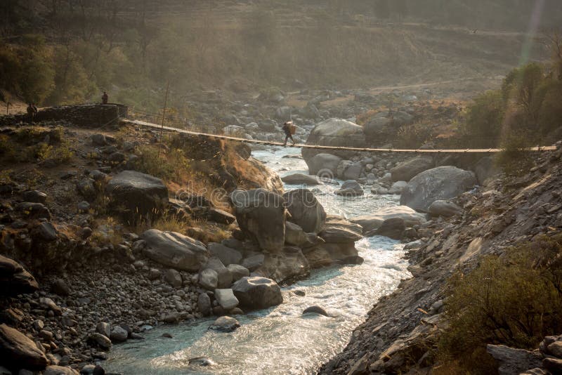 Person Crossing a Swinging Bridge Stock Image - Image of bridge, remote ...
