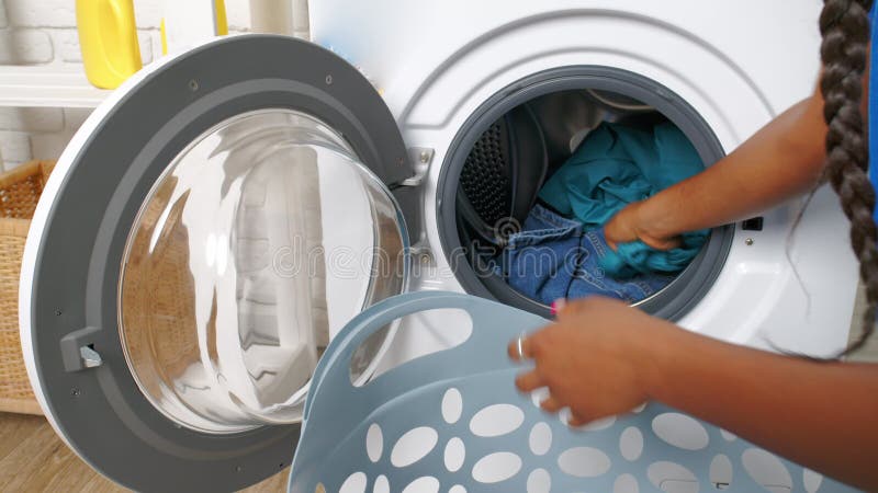 Loading Clothes into a White Washing Machine in a Laundry Room Stock ...