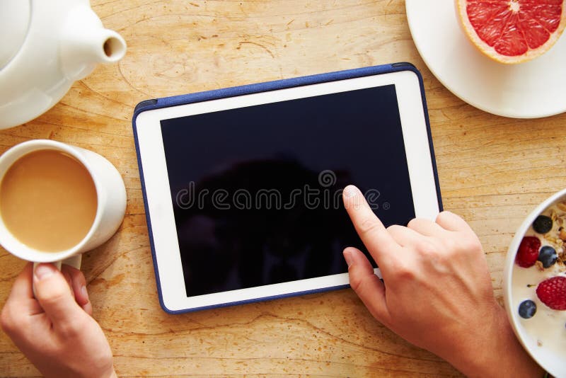 Person Looking at Digital Tablet Whilst Eating Breakfast Stock Photo ...