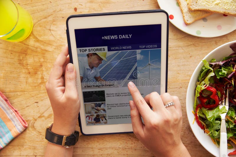 Person at Lunch Looking at News App on Digital Tablet Stock Image ...
