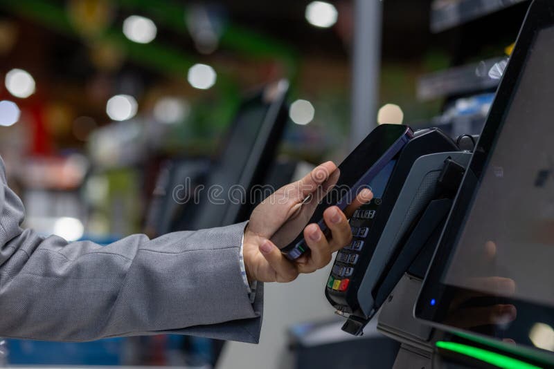 A Person is Making a Payment Using NFC Technology on a Mobile Device at ...