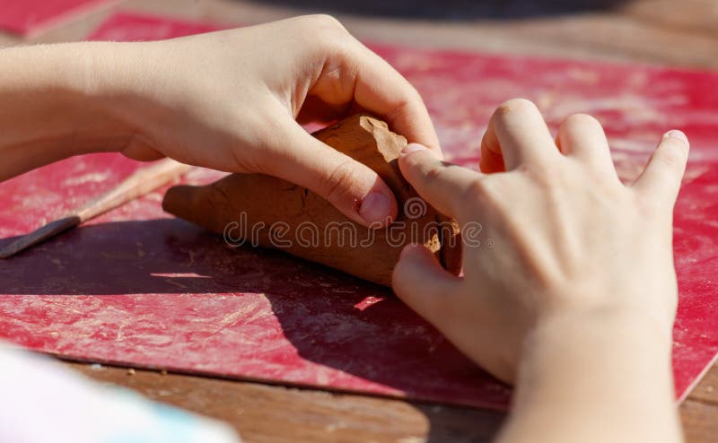 A Person is Making a Small Clay Object on a Red Table Stock Photo ...