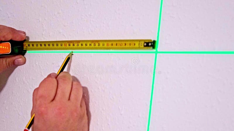 Person Measuring and Marking on the Wall with the Help of a Laser ...