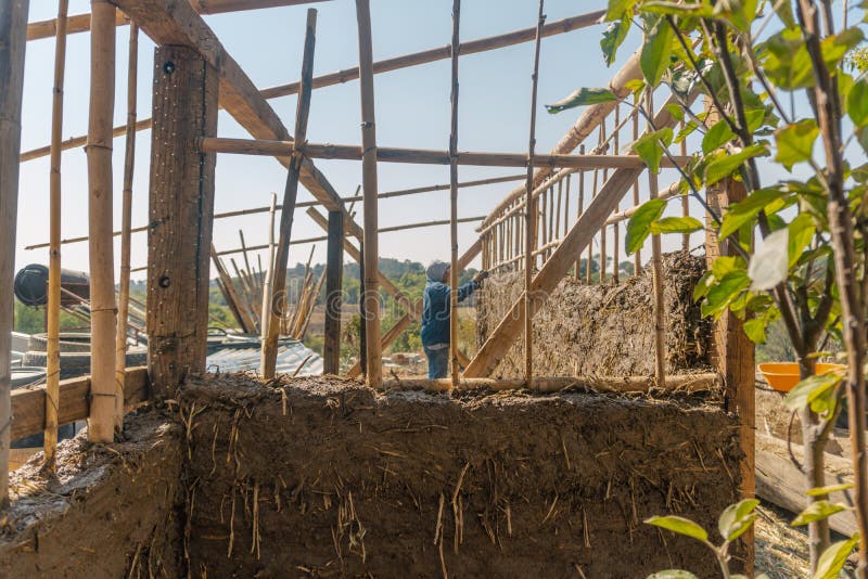 A Person Mixing Straw and Earth for the Technical Construction of ...