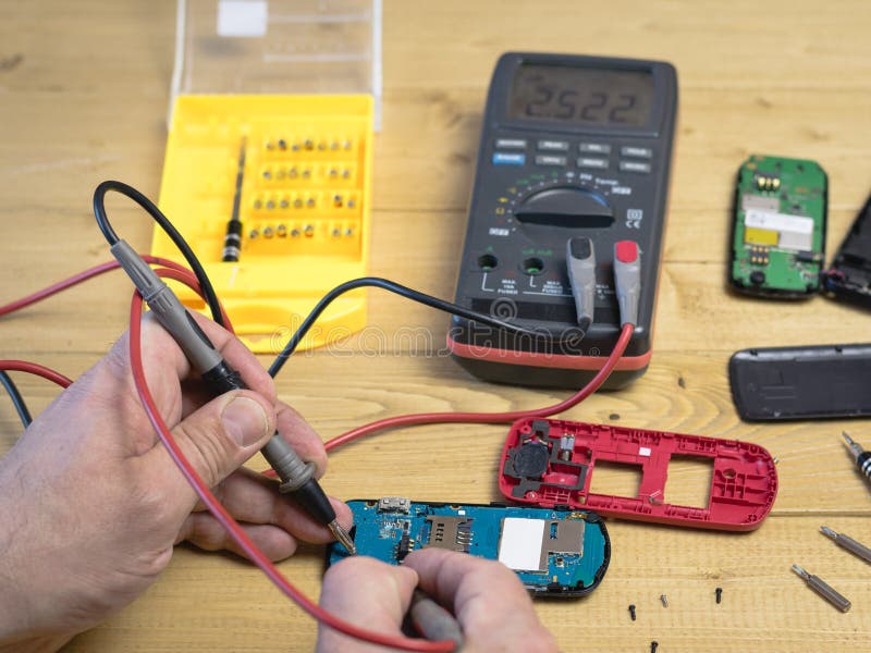 The Person Performs Repair Mobile Phone on a Wooden Table. Stock Photo ...