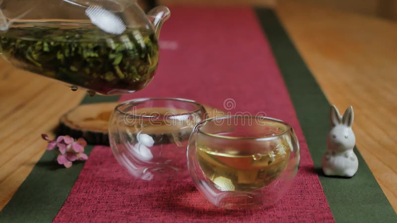 A Person Pours Green Tea into Two Cups, Symbolizing Connection. Media ...