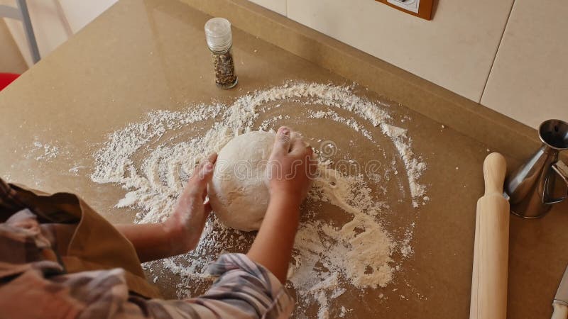 Person Preparing Dough on Floured Surface in a Kitchen Environment ...