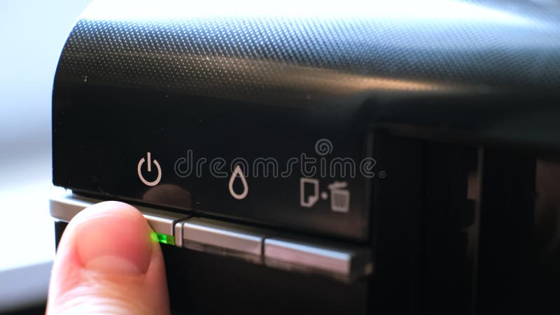 The Person Presses a Button Turning on the Printer. the Device Has a ...