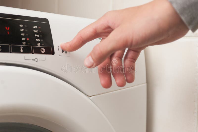 A Person is Pressing a Button on a White Washing Machine Stock Photo ...