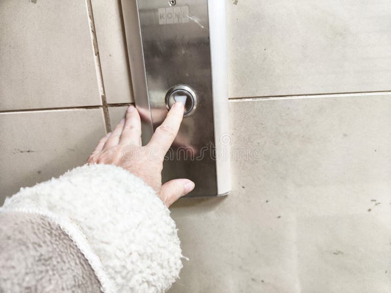 Person Pressing the Elevator Button in a Modern Building during Daytime ...