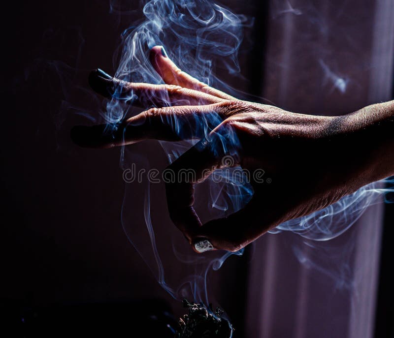 A Person Lighting Their Cigarette with a Lighter in the Background ...