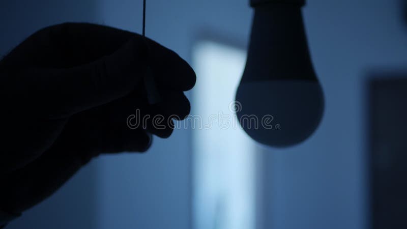 A Person Pulls the Switch Cord with His Hand and Turns Off the Light ...