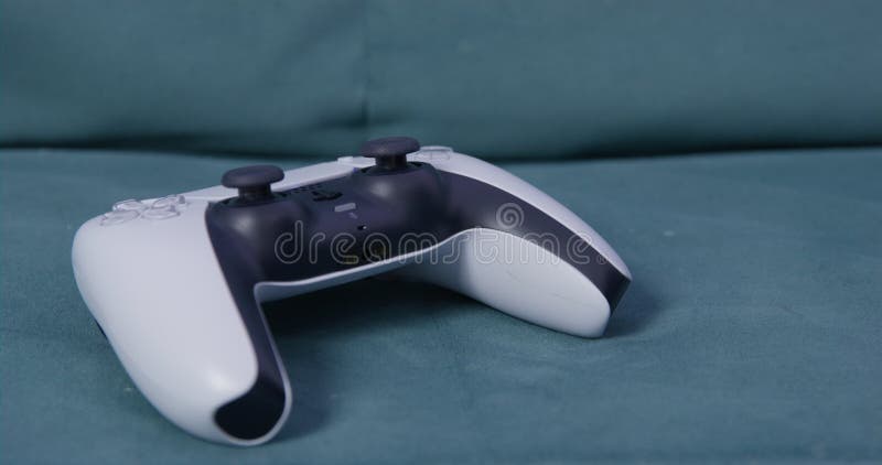 Person Puts Controller for Game Console on Blue Sofa during a Break ...