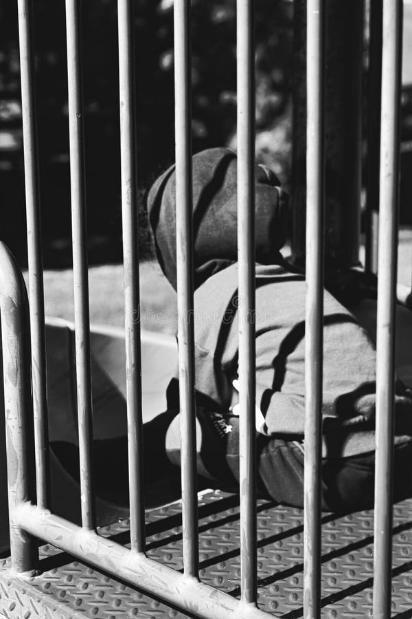 A Person Laying on a Bench in Front of a Gate Stock Image - Image of ...