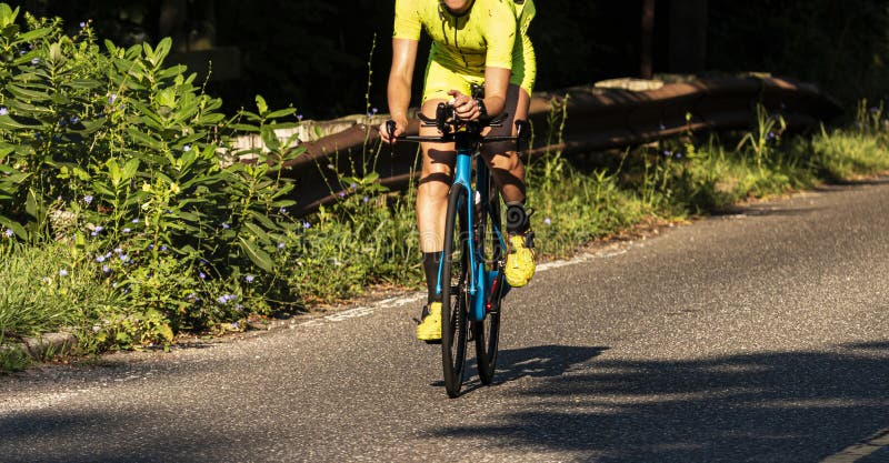 A Person Riding a Racing Bike Down a Road in the Sunlight Stock Image ...