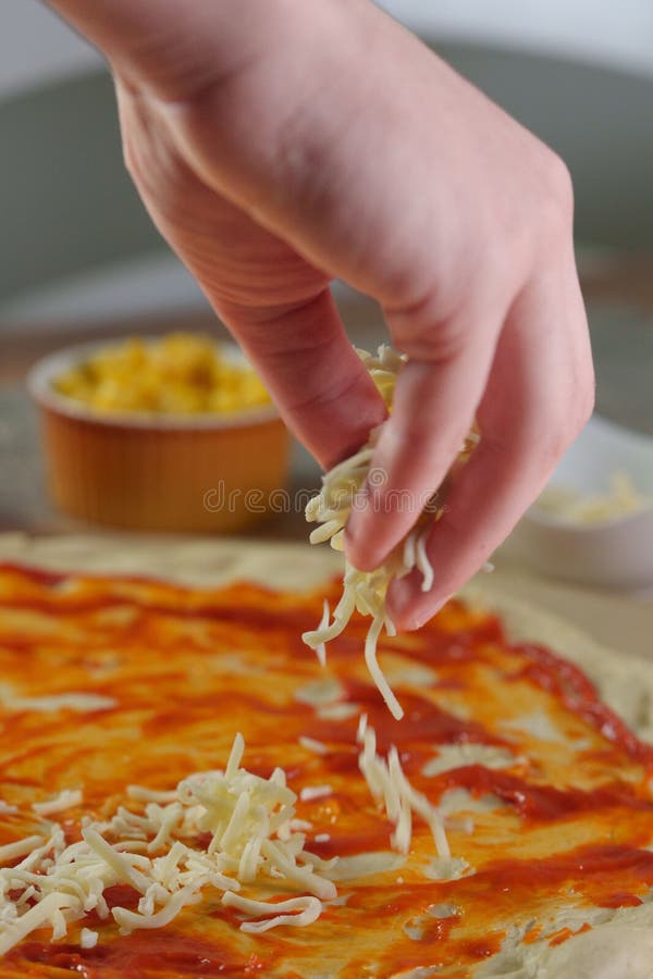 Person S Hand Adding Grated Cheese To Pizza, Process of Making Pizza ...