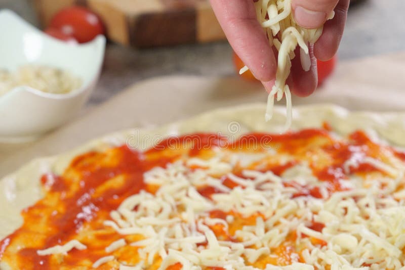 Person S Hand Adding Grated Cheese To Pizza, Process of Making Pizza ...