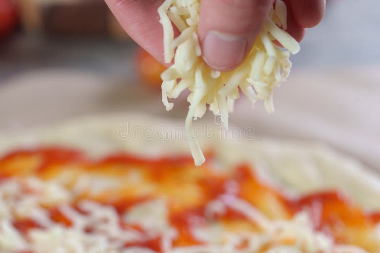 Person S Hand Adding Grated Cheese To Pizza, Process of Making Pizza ...