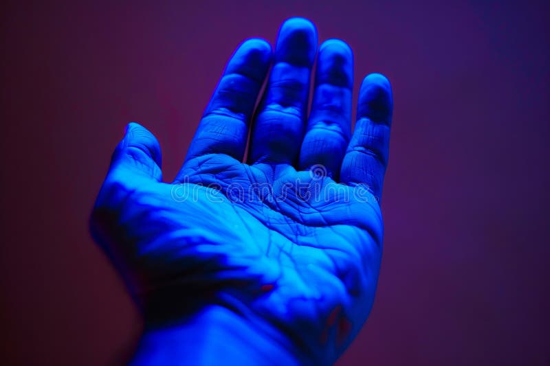 A Person S Hand is Painted Blue and Lit Up Stock Photo - Image of ...