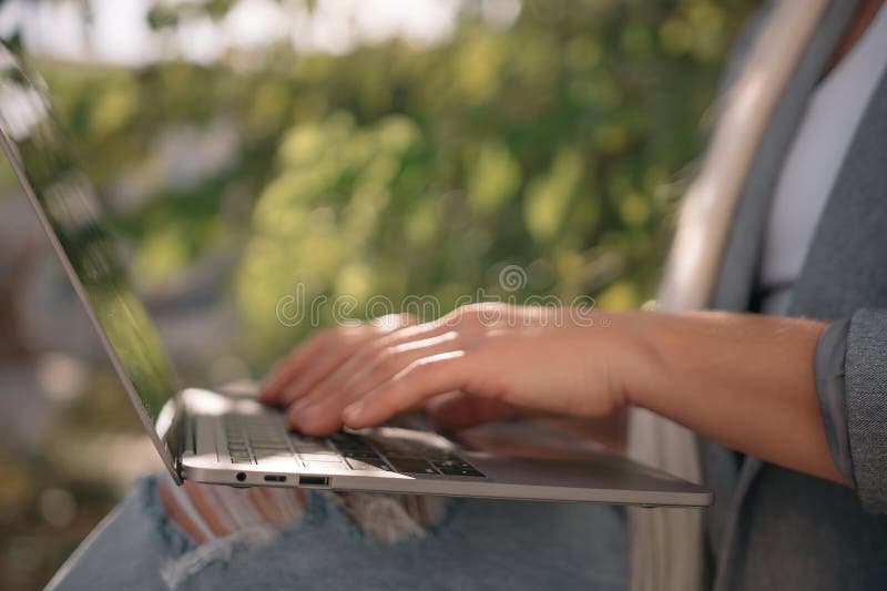 A Person is Sitting on a Bench with a Laptop Open in Front of Them ...