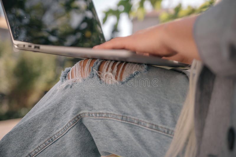 A Person is Sitting on a Bench with a Laptop Open in Front of Them ...