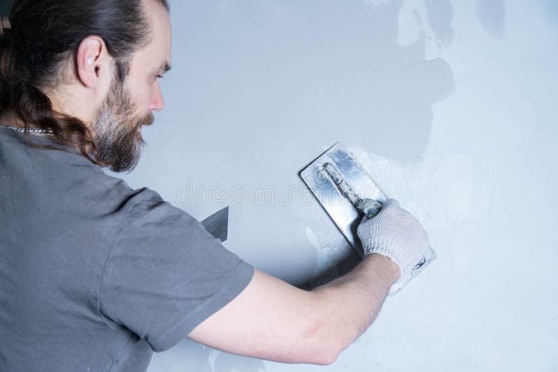 Man Applying Epoxy Adhesive To a Wall Surface for Repair Work with a ...