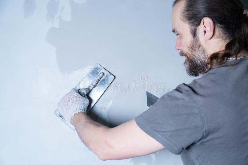 Man Applying Epoxy Adhesive To a Wall Surface for Repair Work with a ...