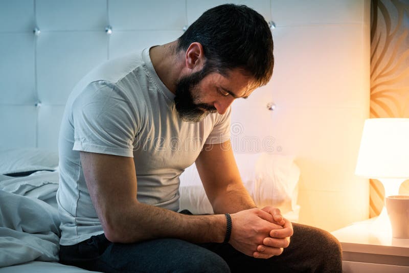 Person With Some Kind Of Problem Sitting On The Bed And With His Head